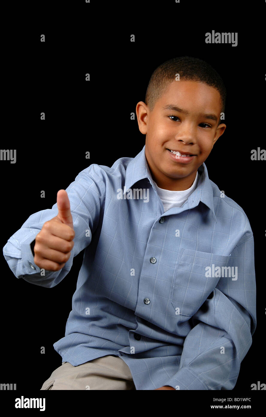 Young African American boy showing the thumbs up over a black ...