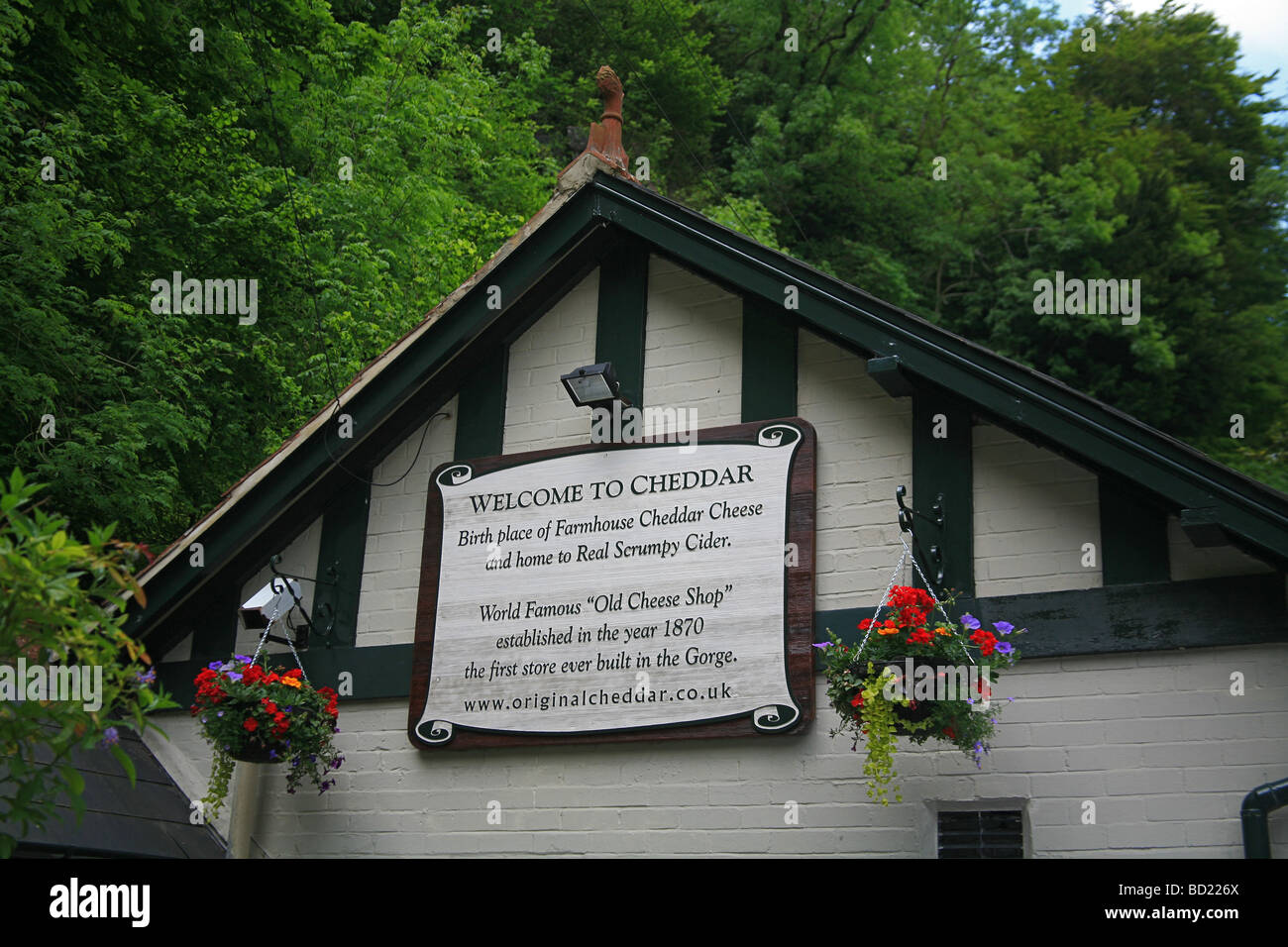 Sign and hanging baskets on the side of a shop in the Cheddar Gorge ...