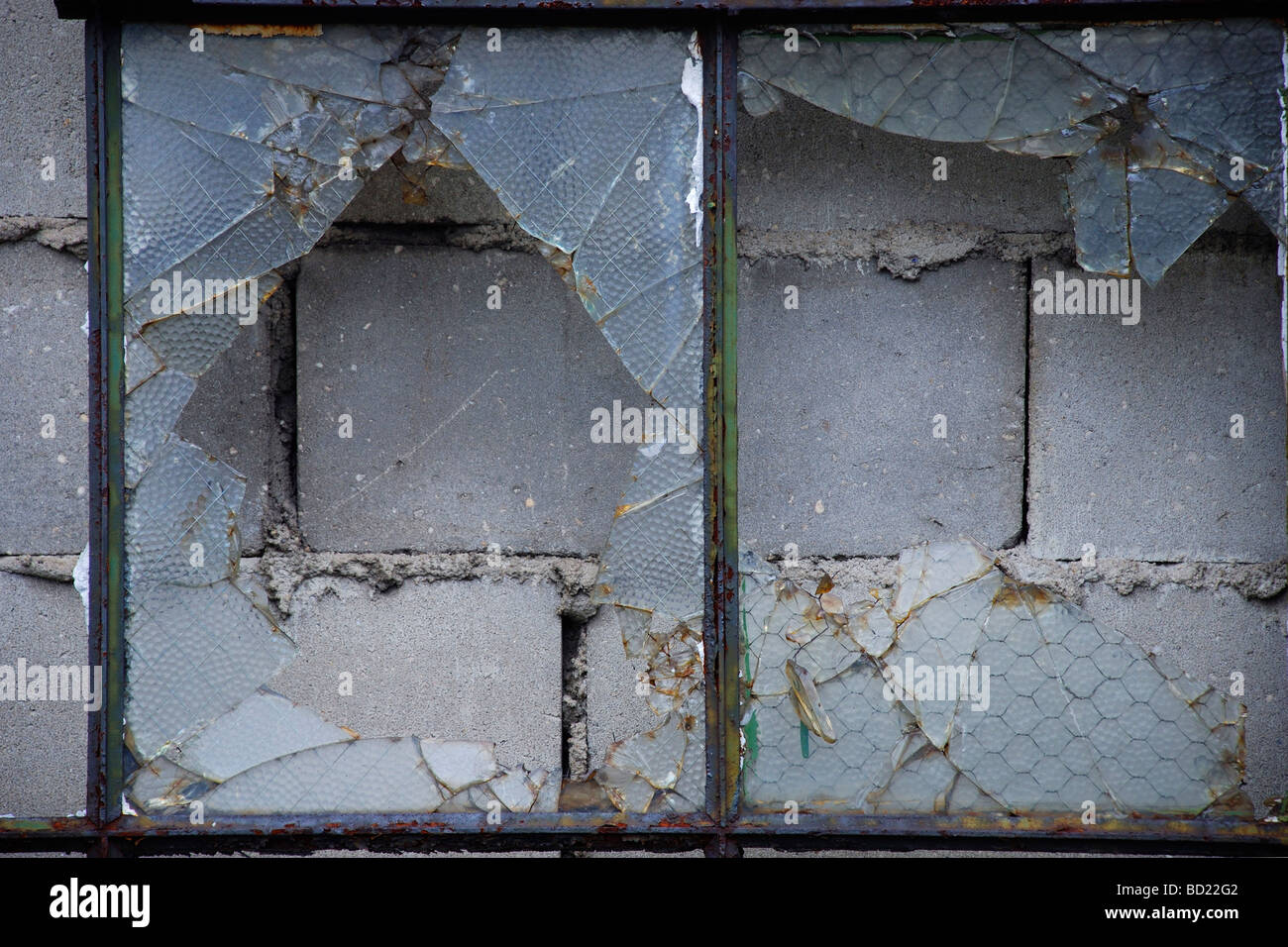 Gritty exterior brick wall with broken window blocked up with cinder ...