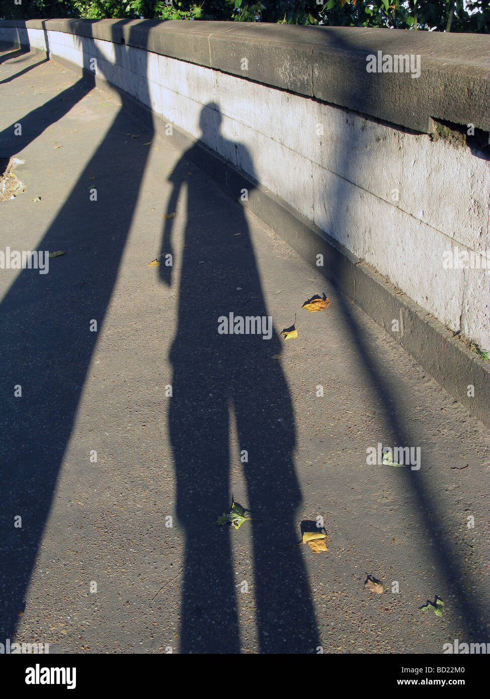 man's long shadow on pavement in city town Stock Photo - Alamy
