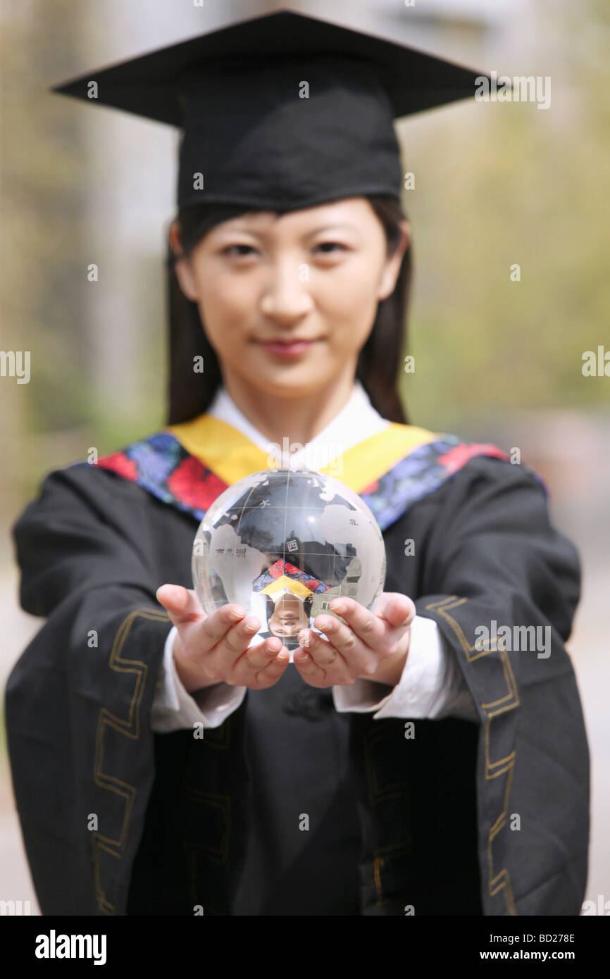 Chinese girl in graduation gown holding crystal ball,China Stock Photo ...