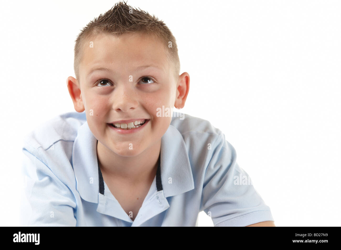young boy looking up and smiling on white background with space for ...