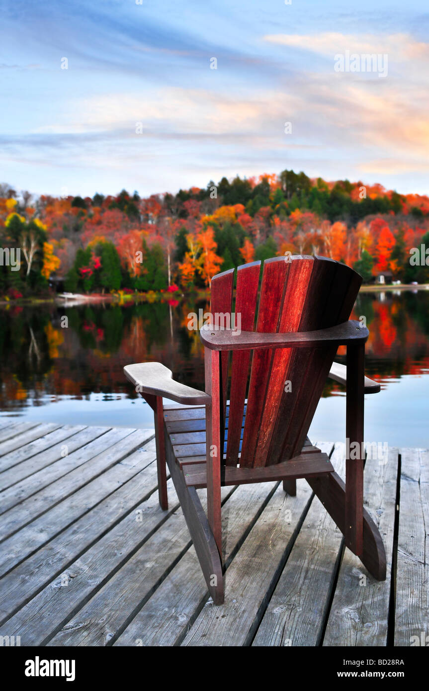Wooden dock with chair on calm fall lake Stock Photo - Alamy