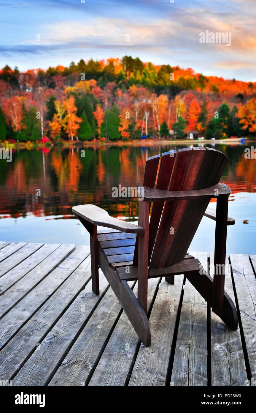 Wooden dock with chair on calm fall lake Stock Photo - Alamy