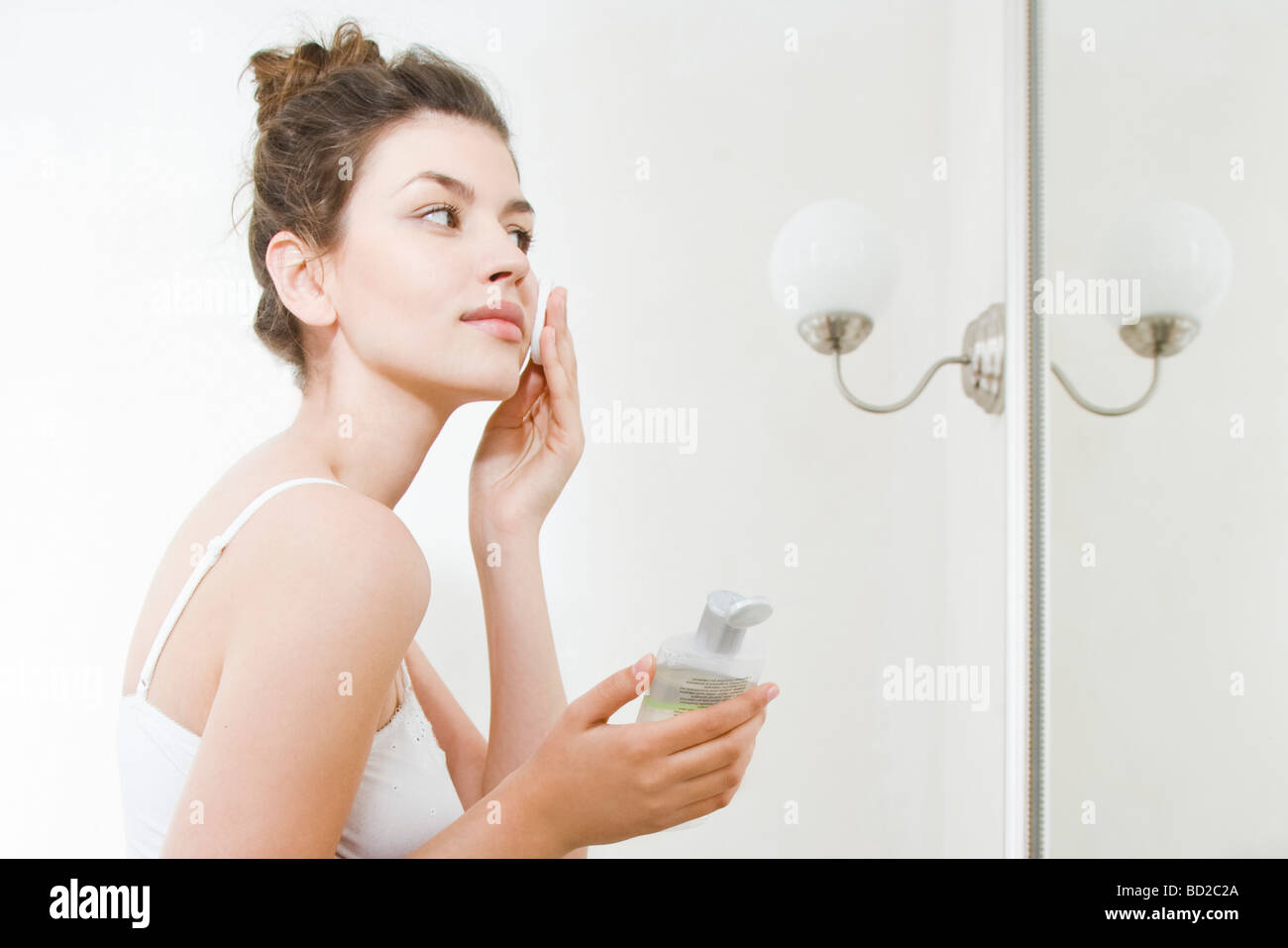 Woman applying face tonic Stock Photo - Alamy