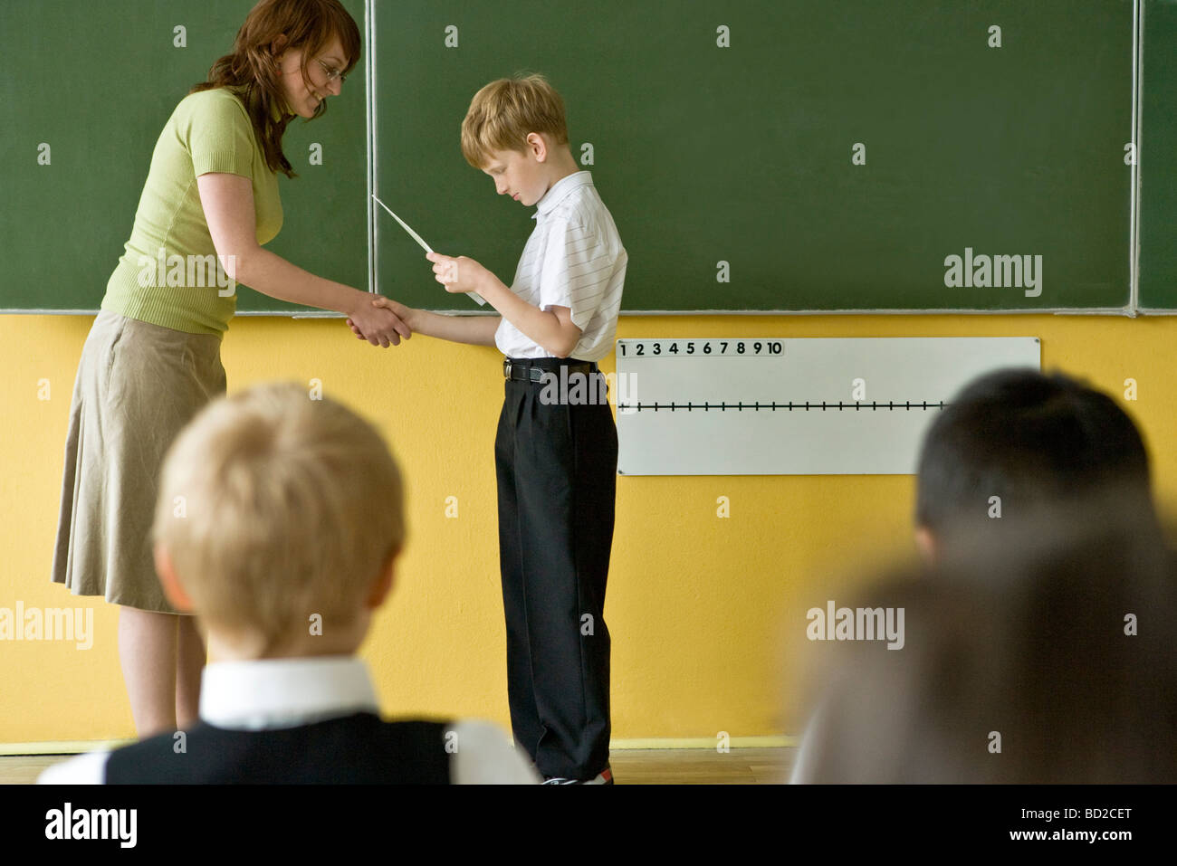 Teacher giving school reports to children Stock Photo - Alamy