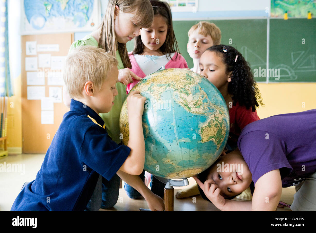 children looking at globe in class Stock Photo - Alamy