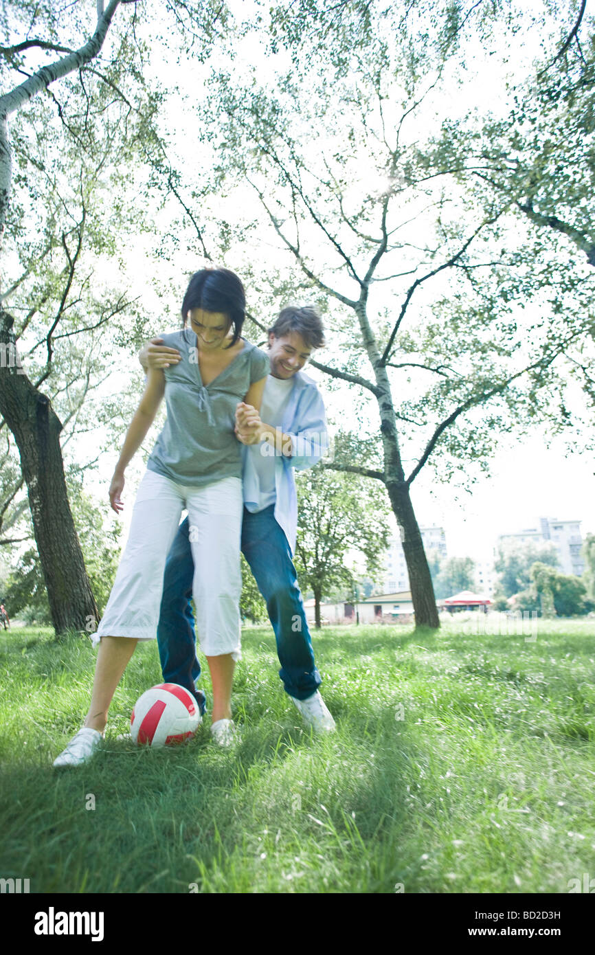 couple playing football in park Stock Photo - Alamy