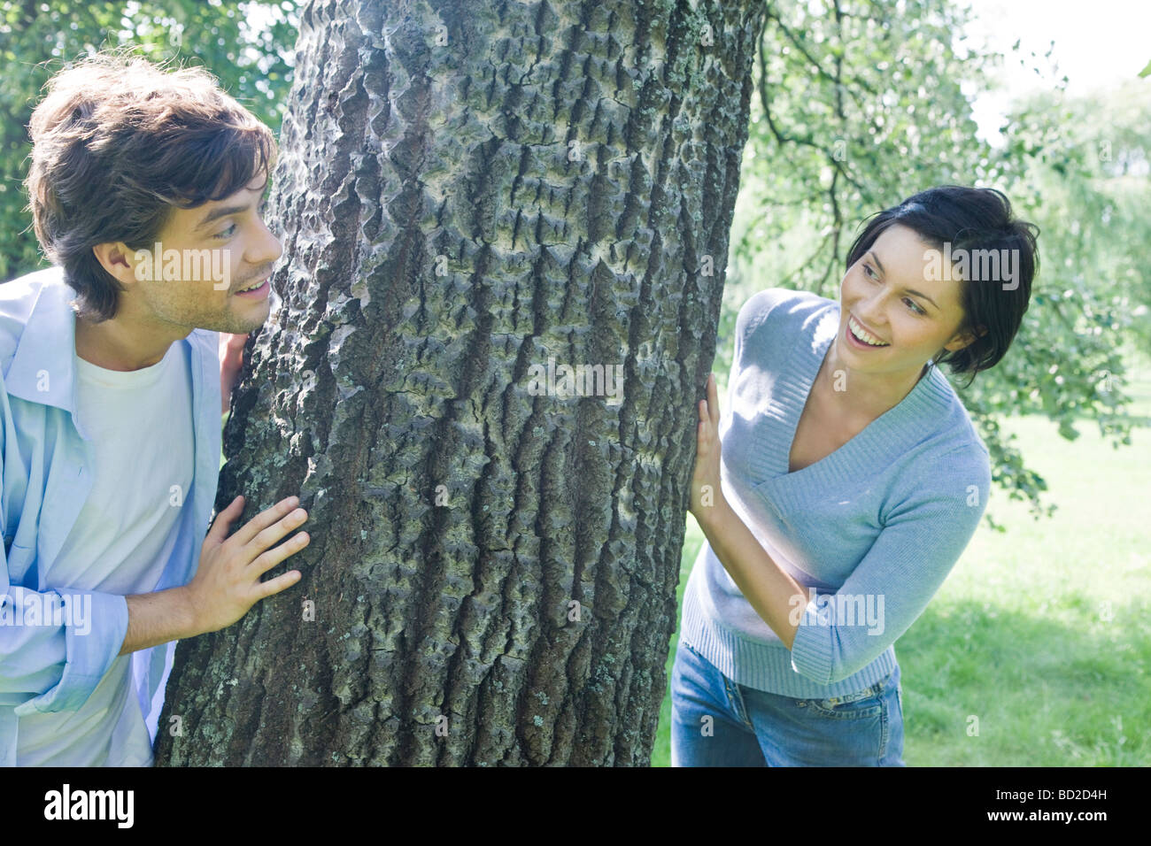 couple hiding behind tree Stock Photo - Alamy