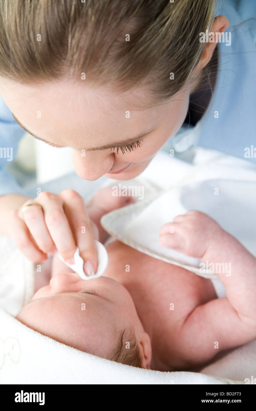 mum cleaning infants face Stock Photo - Alamy