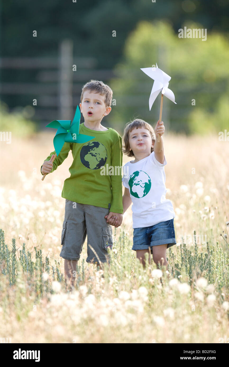 Kids playing with windmills on meadow Stock Photo - Alamy