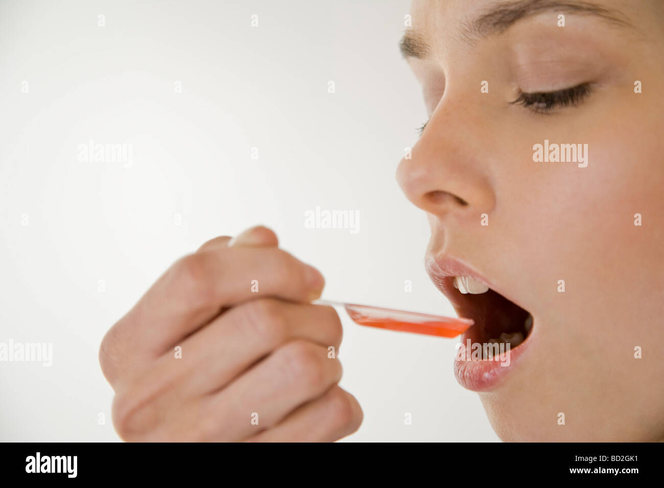 Young woman taking syrup Stock Photo - Alamy