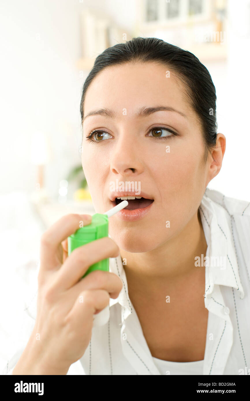 Woman using throat spray Stock Photo - Alamy