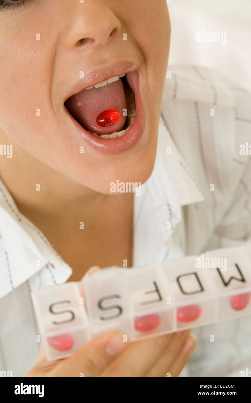 Woman taking pill Stock Photo - Alamy