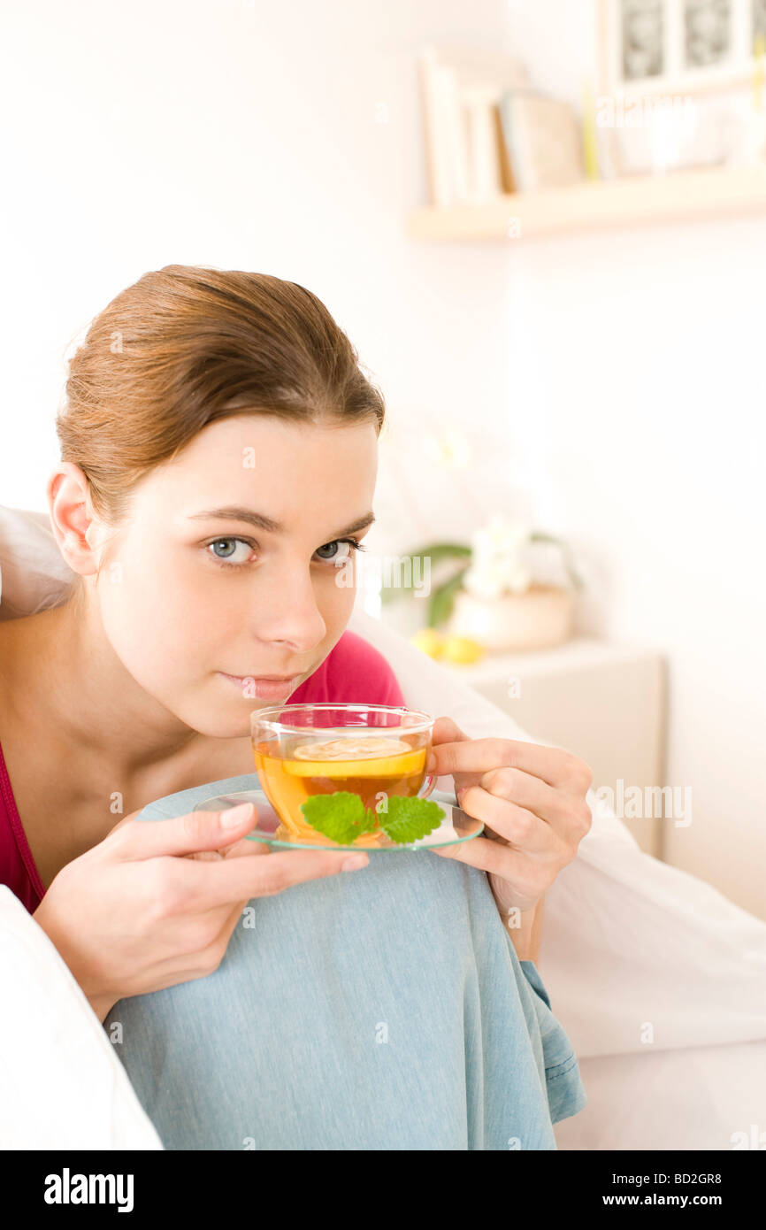 Sick woman drinking tea with lemon Stock Photo - Alamy