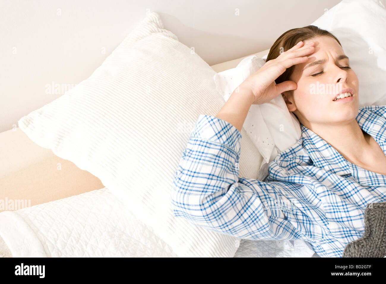 Sick woman laying in bed Stock Photo - Alamy