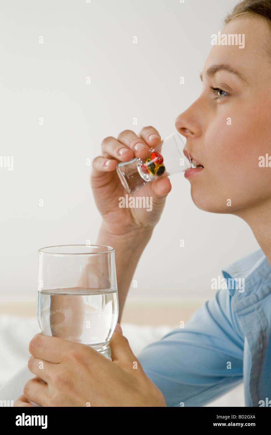 Young woman taking pills Stock Photo - Alamy
