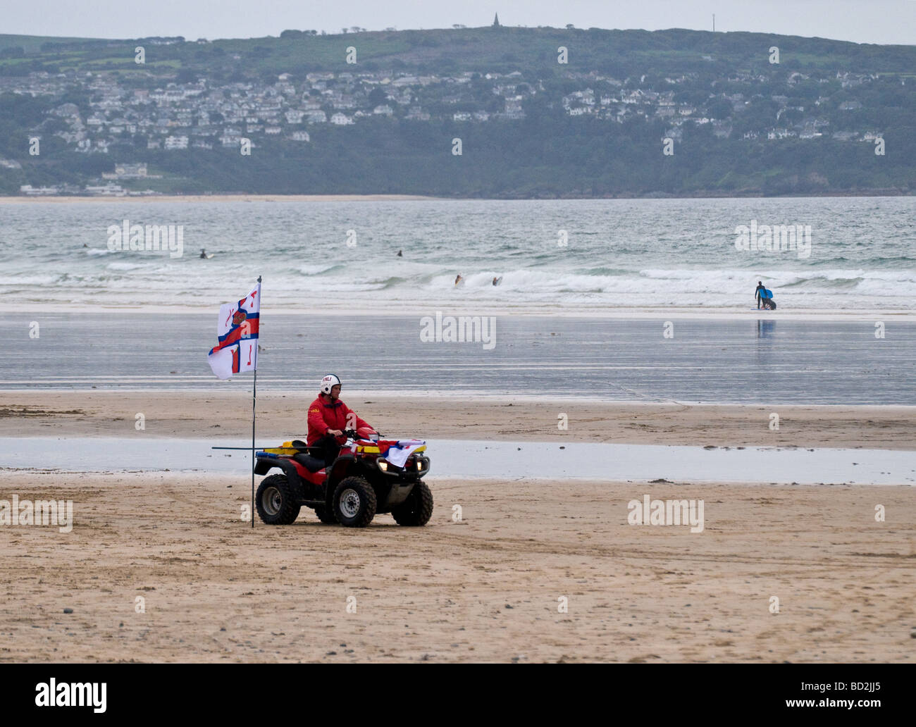 A RNLI lifeguard on a quad bike patrolling Gwithian Towans beach in ...