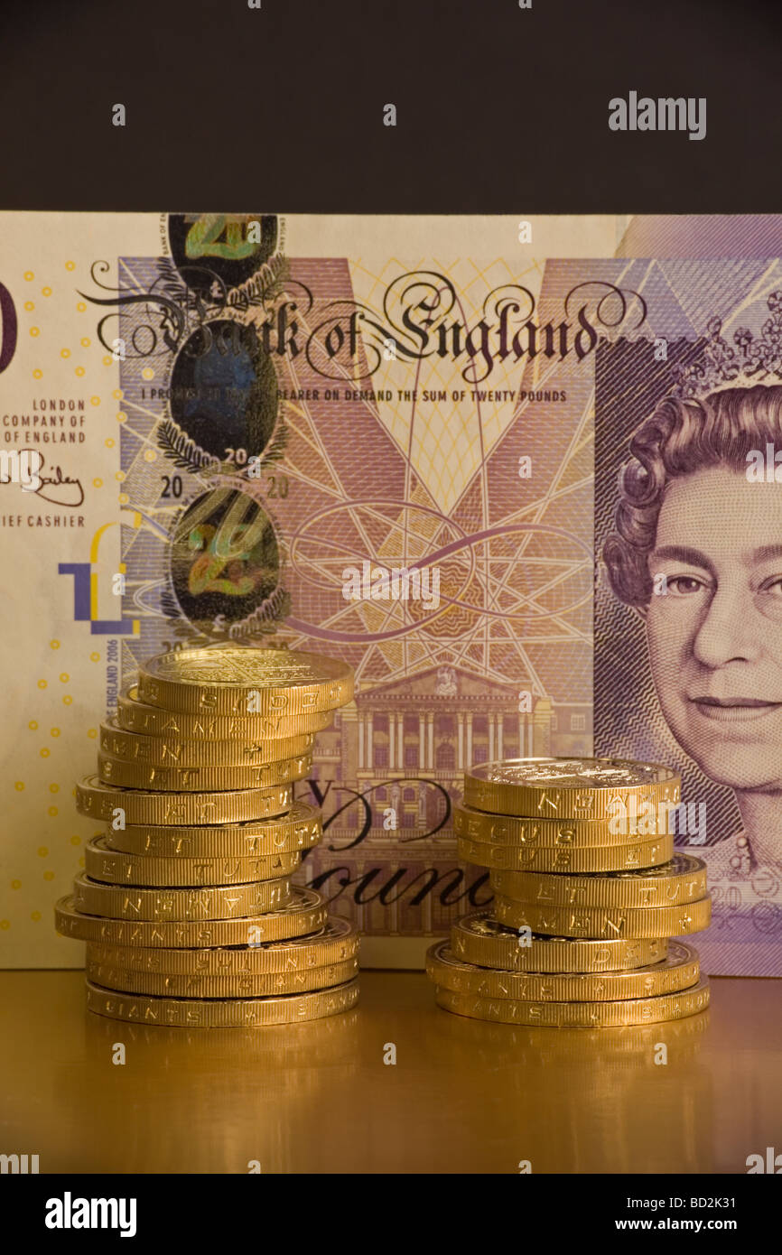One and two pound coins in two stacks with twenty pound note Stock ...