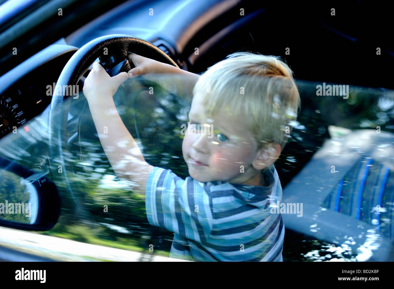 Child blond boy driving real car Stock Photo - Alamy
