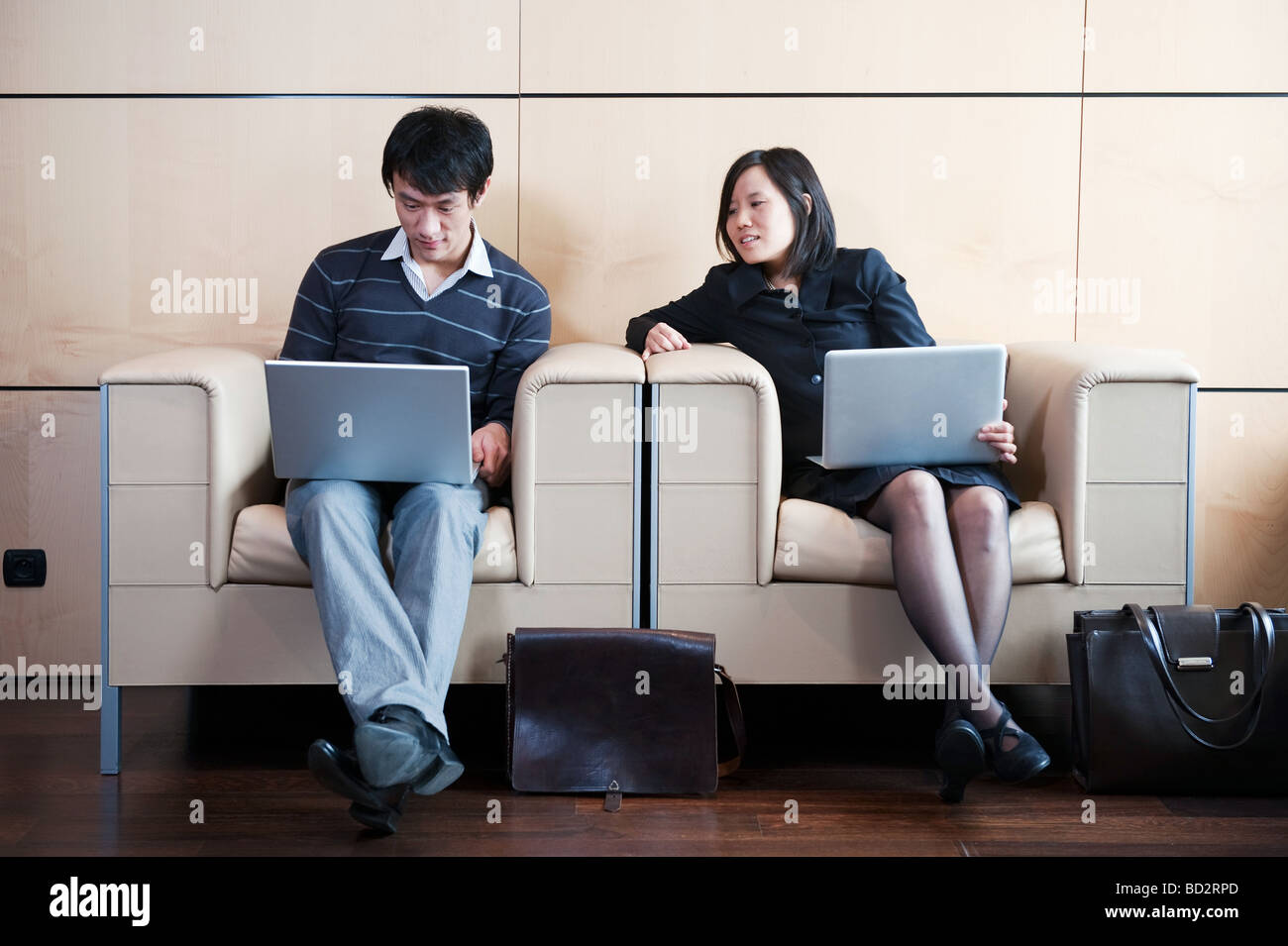 Man, woman working while waiting Stock Photo - Alamy