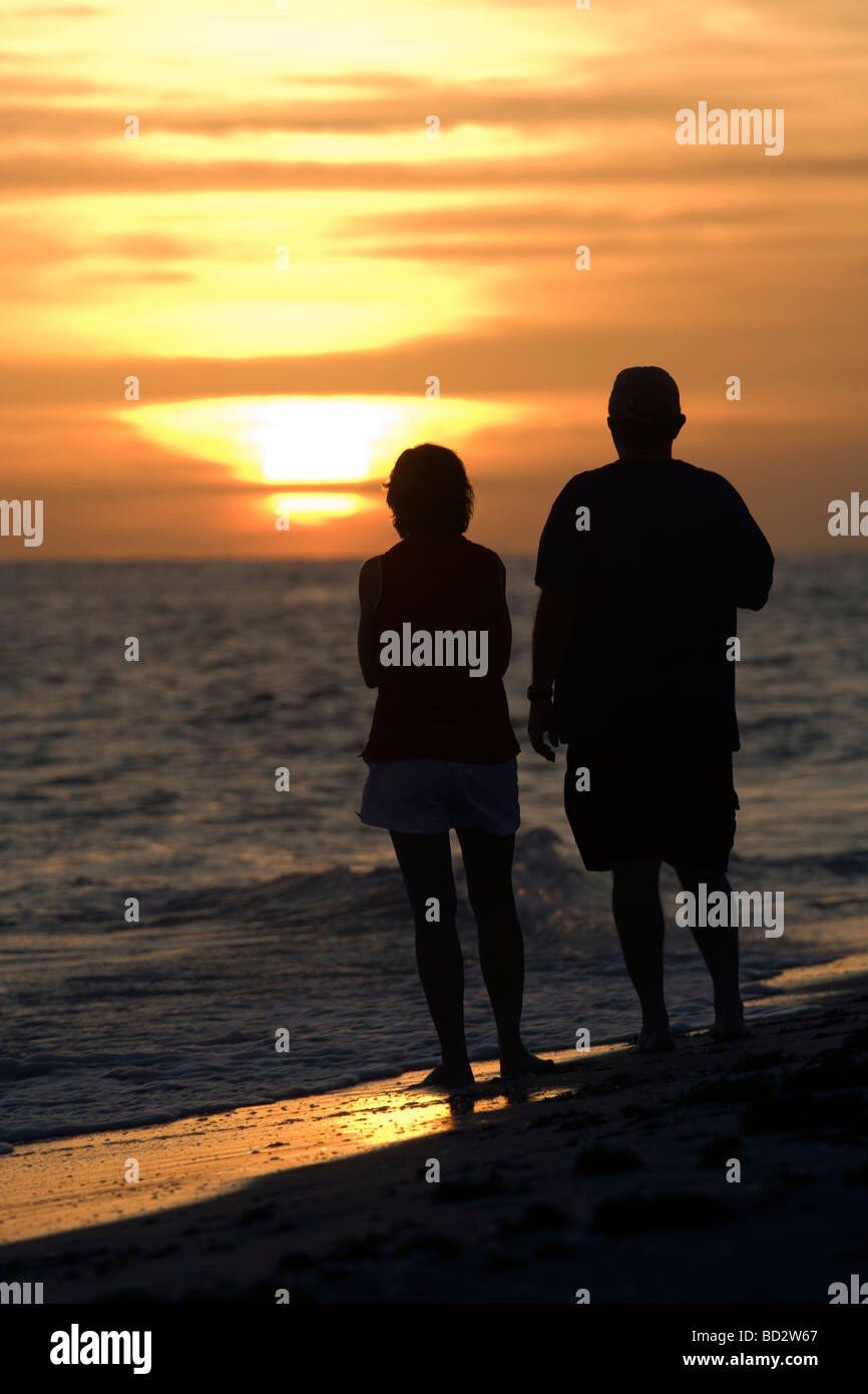 Couple watching sunset on the beach hi-res stock photography and images ...