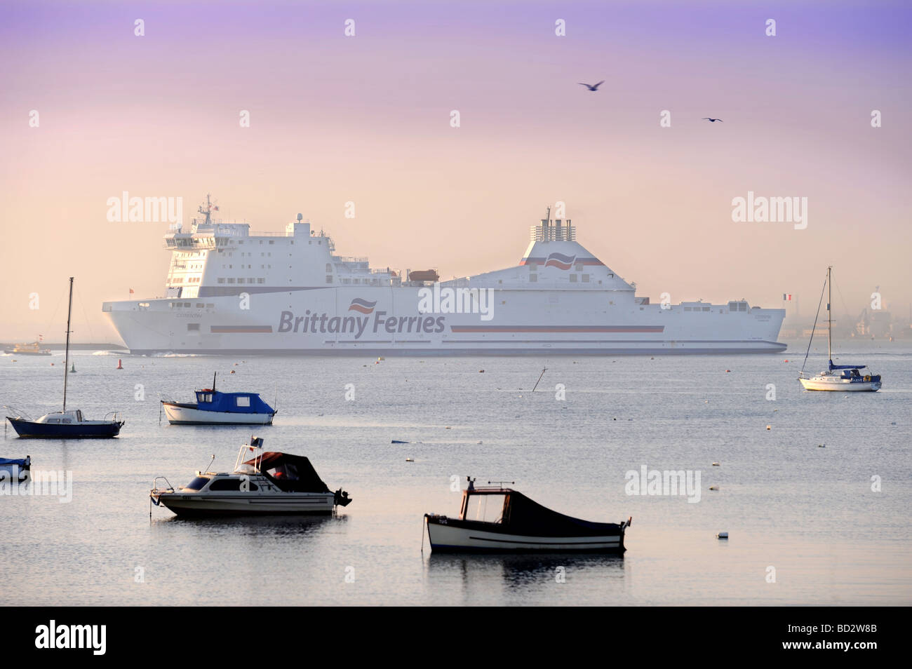A BRITTANY FERRIES SHIP LEAVING POOLE HARBOUR FOR CHERBOURG AT SUNSET ...