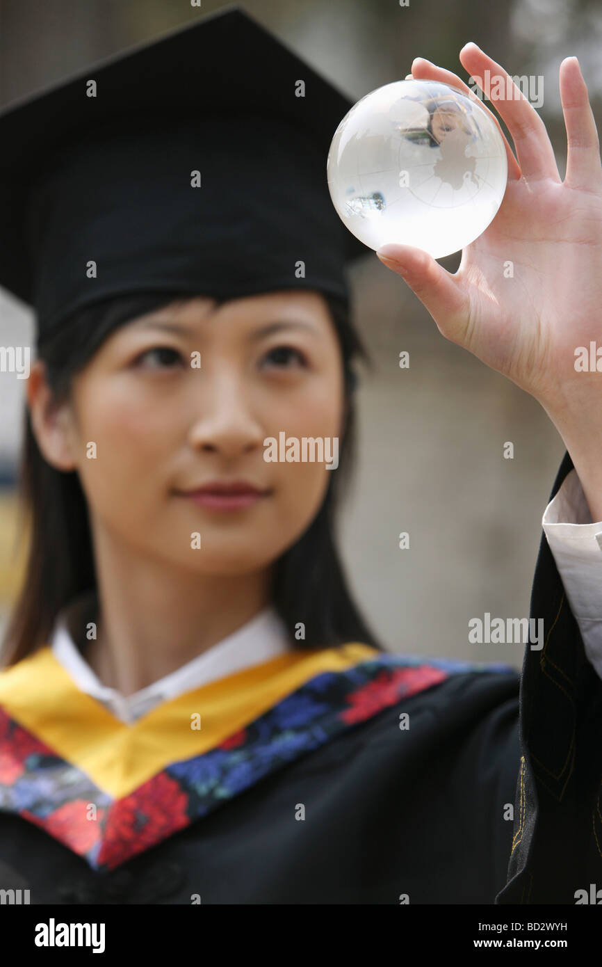 Chinese girl in graduation gown holding crystal ball,China Stock Photo ...