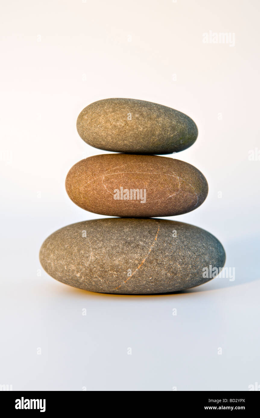 Still life shot of three beach pebbles balanced in a stone pile against ...