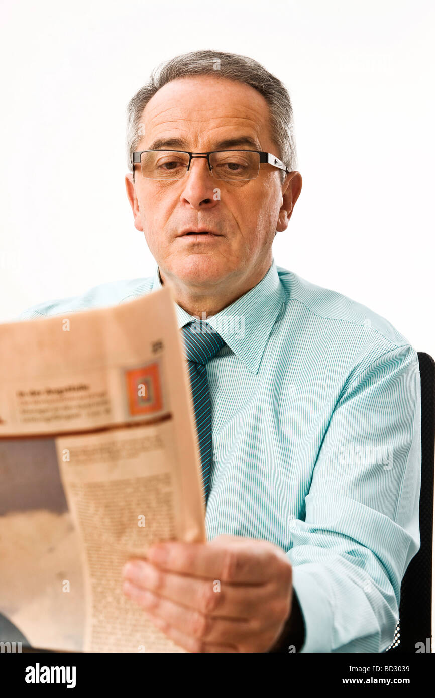 Manager with glasses reading a newspaper concentratedly Stock Photo - Alamy