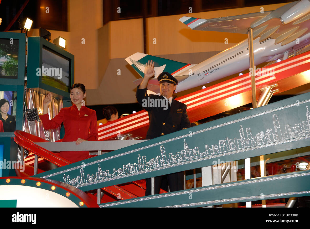 A Cathay Pacific flight attendant and a pilot taking part in a parade ...