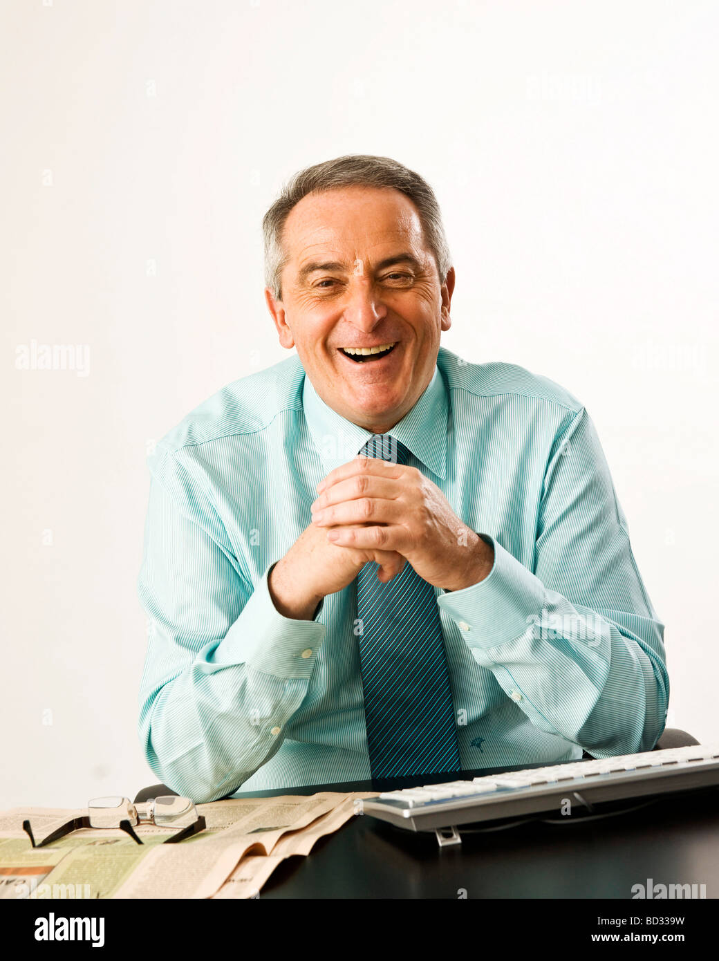 Laughing manager sitting at his desk Stock Photo - Alamy