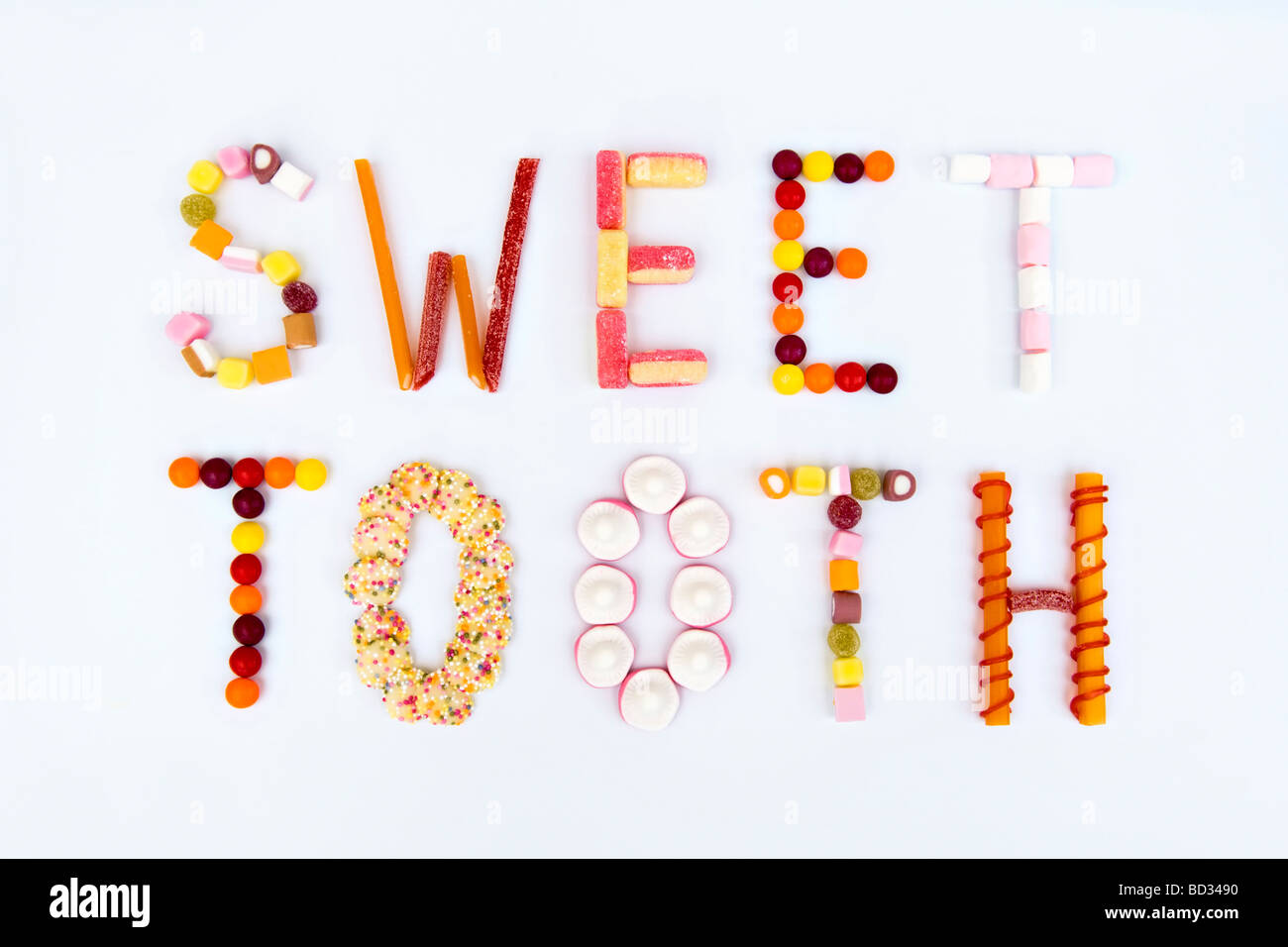 Still life artistic shot of sweets against a white background spelling ...