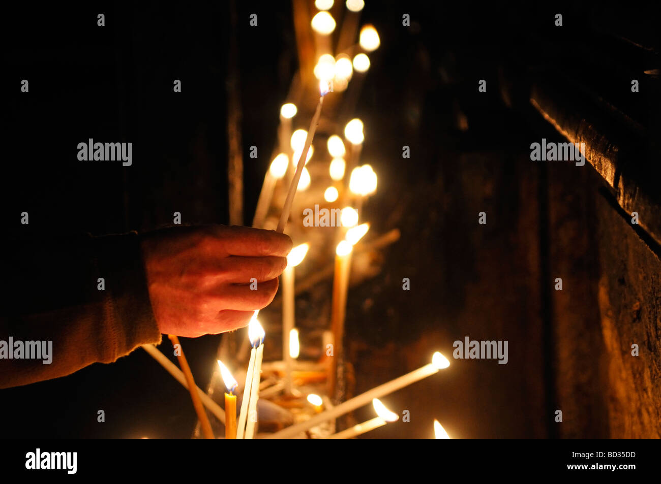 Christian pilgrim lights a candle at the Church of the Holy Sepulchre ...
