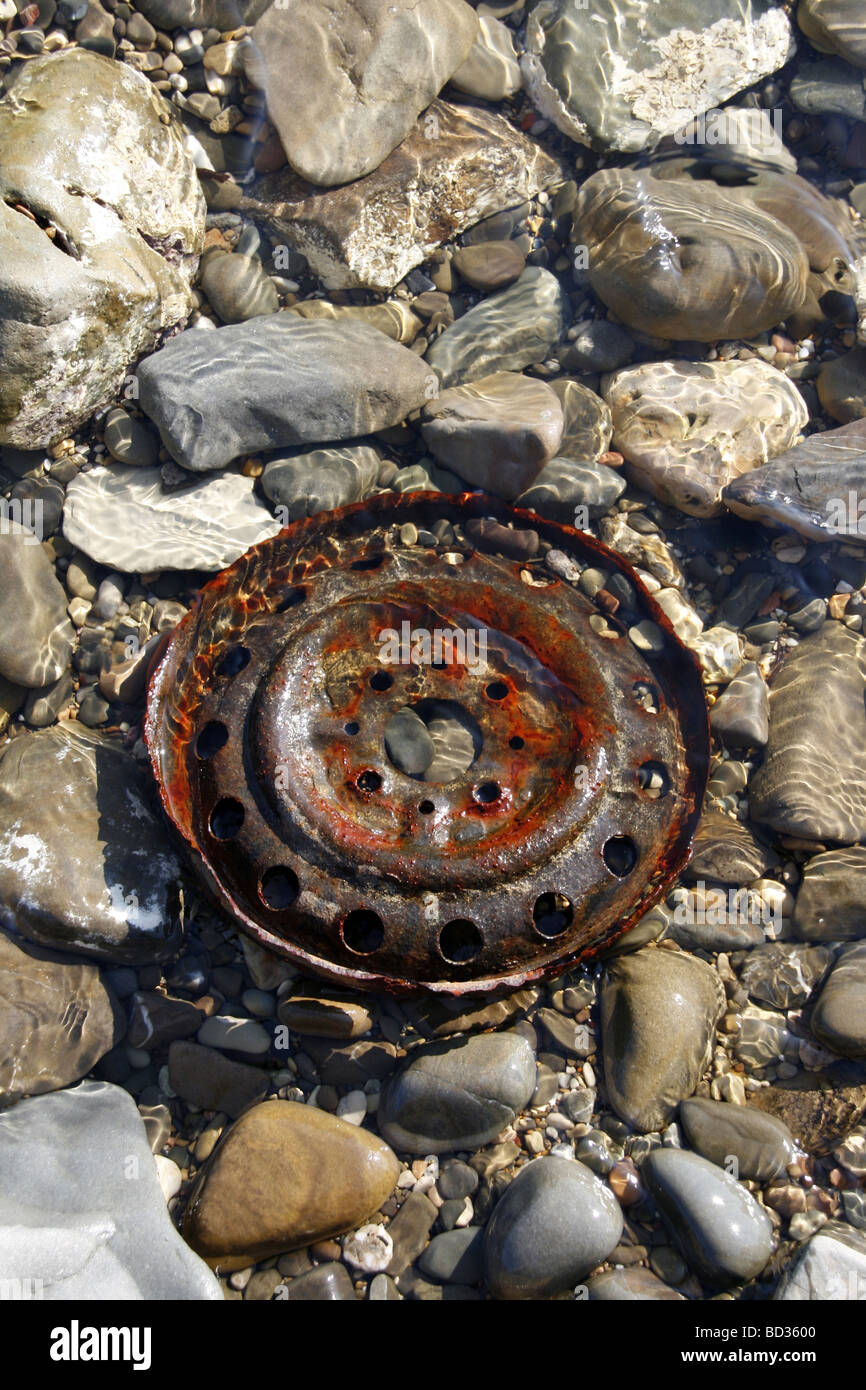 old rusted car wheel dumped in sea water on coast Stock Photo - Alamy