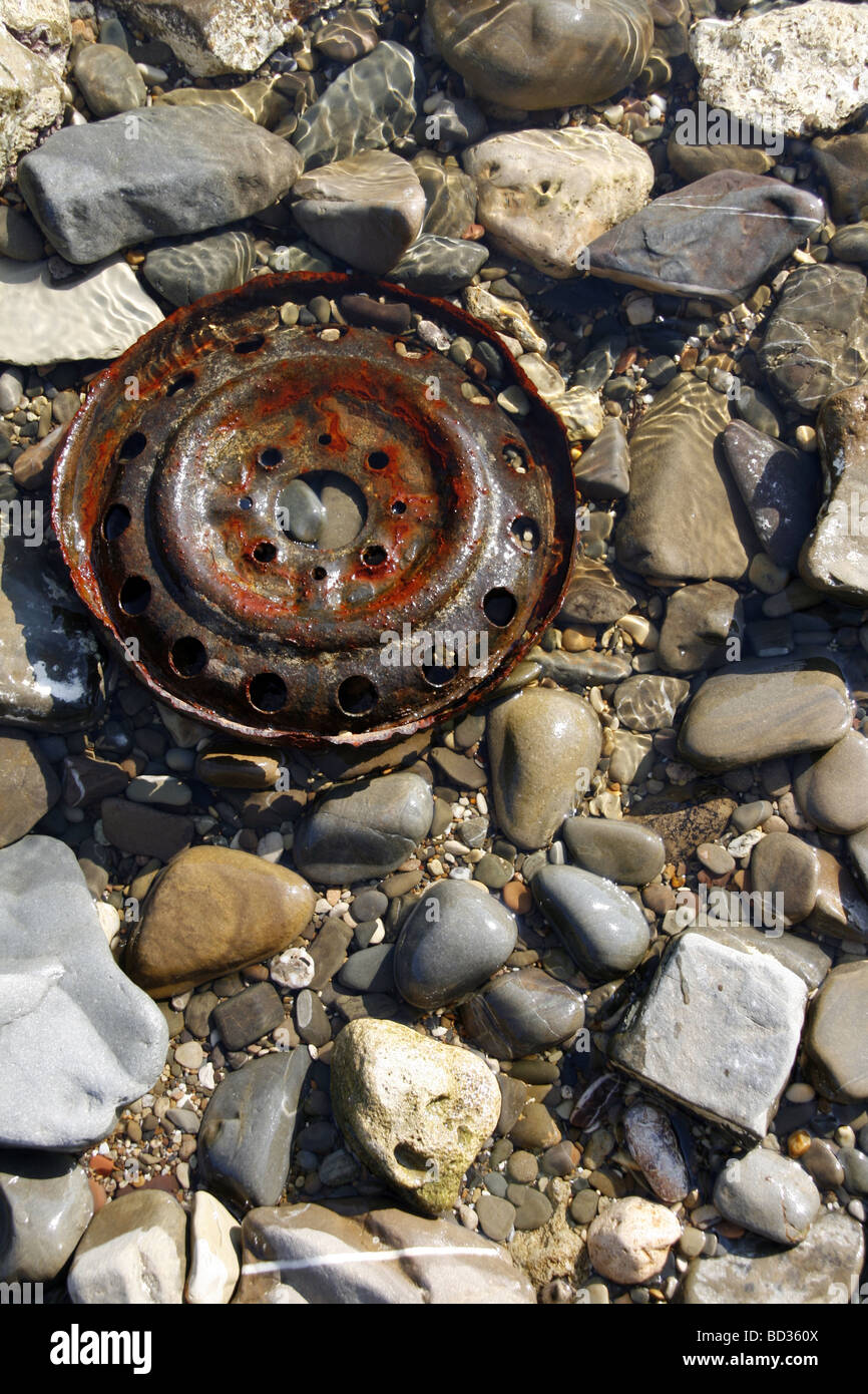 old rusted car wheel dumped in sea water on coast Stock Photo - Alamy