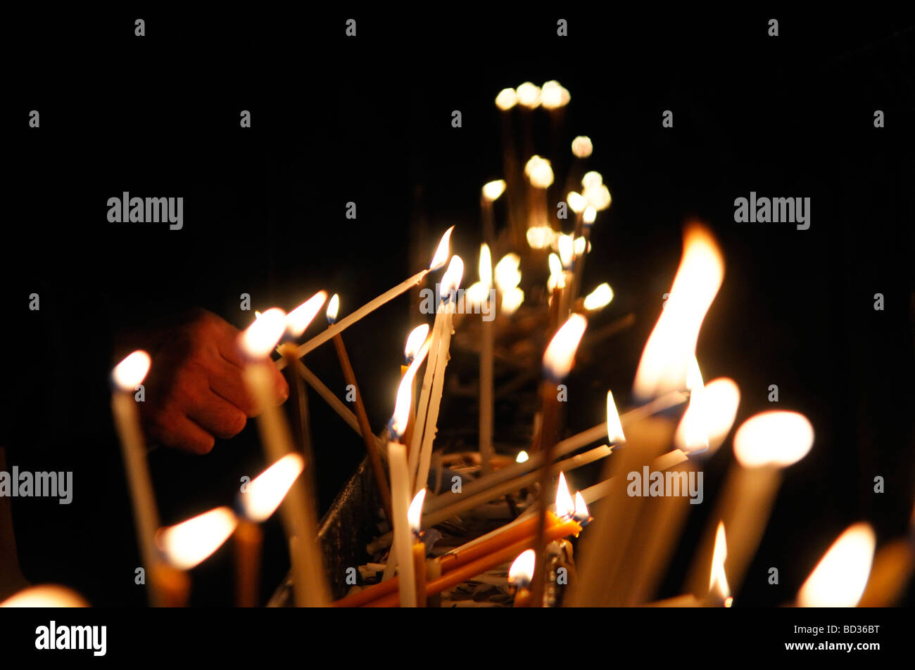 Christian pilgrim lights a candle at the Church of the Holy Sepulchre ...