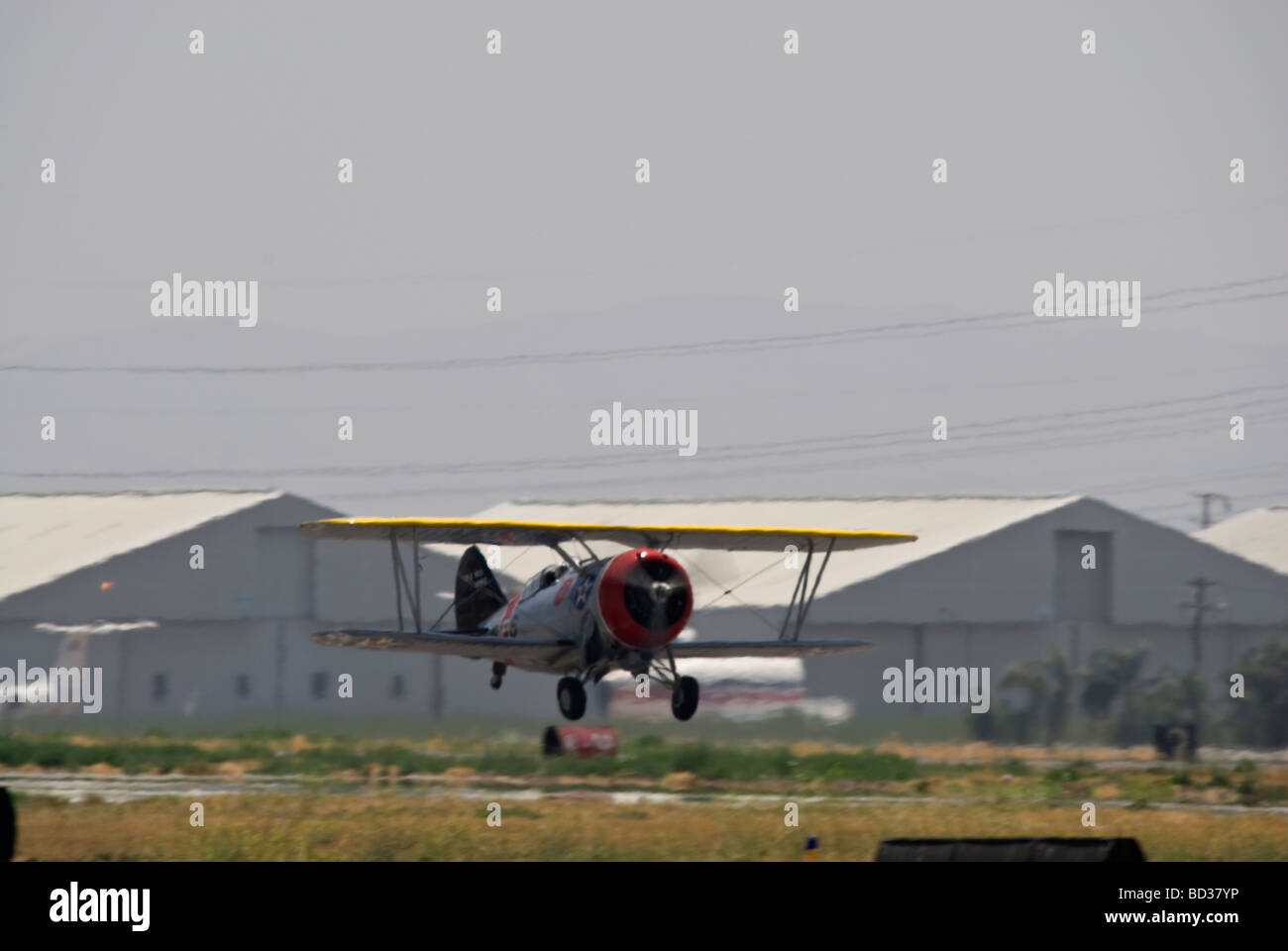A Grumman F3F-2 biplane as it just lifts off the runway to fly at an ...