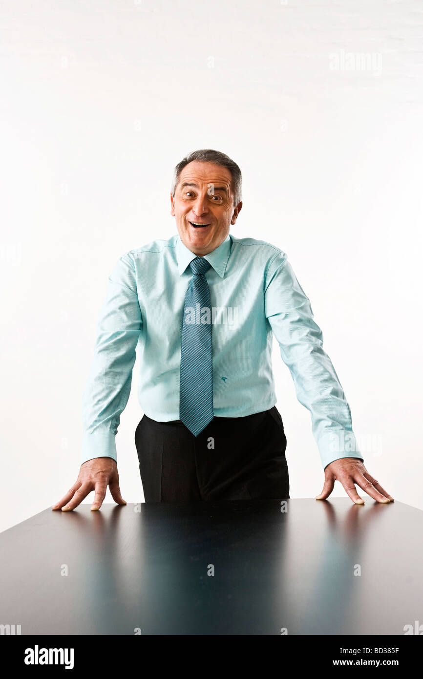 Manager leaning on his desk and laughing Stock Photo - Alamy