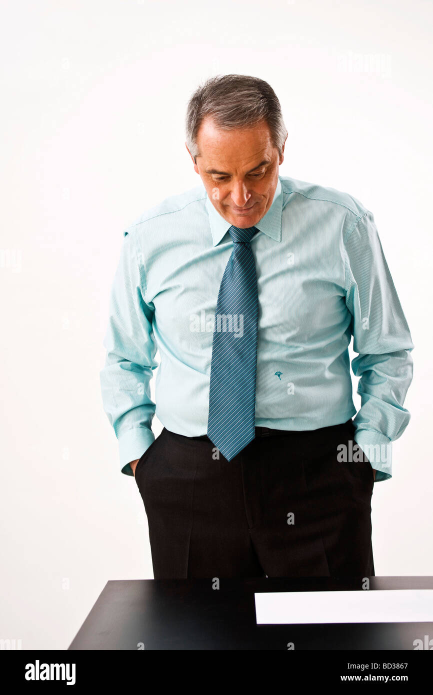 Thoughtful manager facing his desk Stock Photo - Alamy