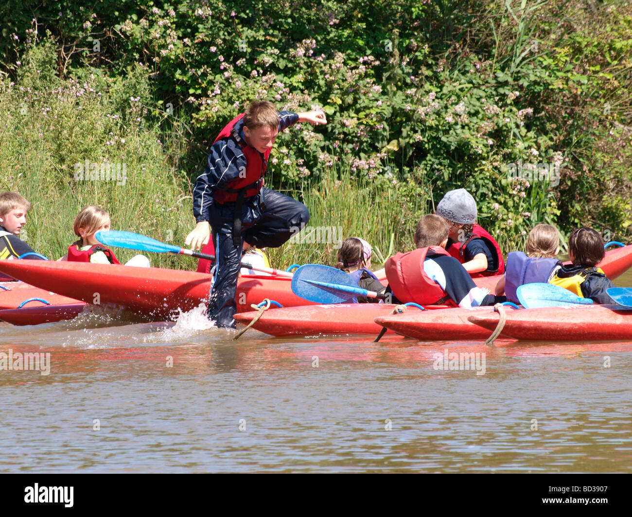 Boy running over the back of canoes part of canoe training at adventure ...
