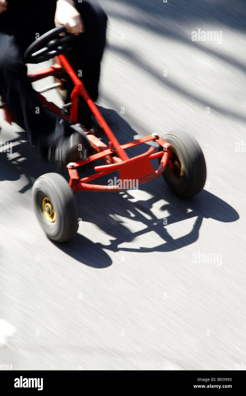 boy riding fast go kart car in street in park Stock Photo - Alamy