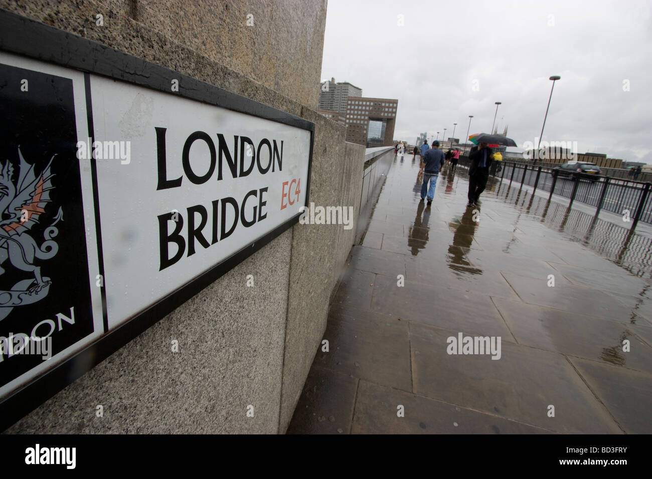 London Bridge with rain, commuters walk over London Bridge UK, with ...