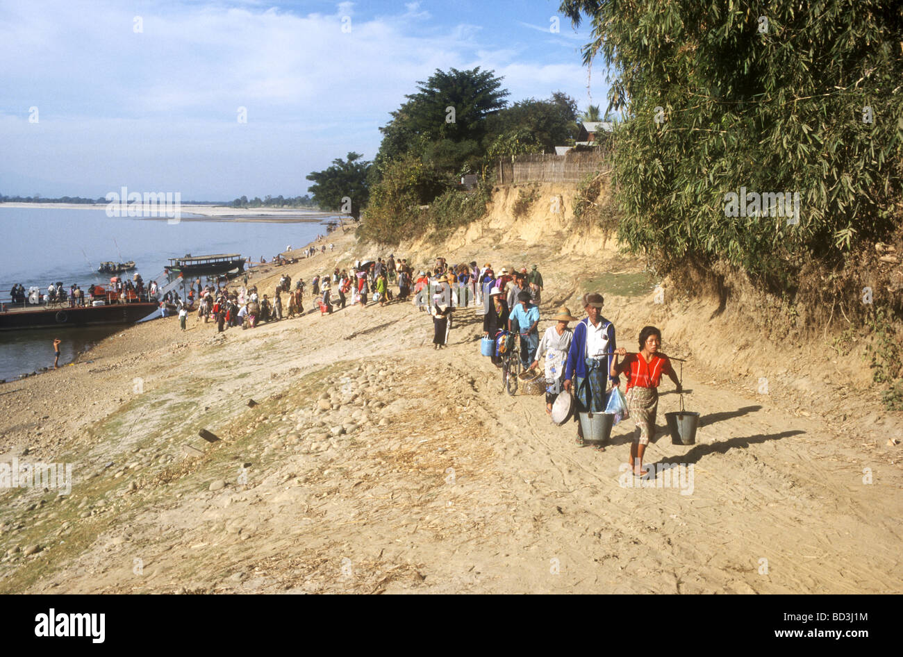 Local people climbing up the riverbank from one of the many ferries on ...