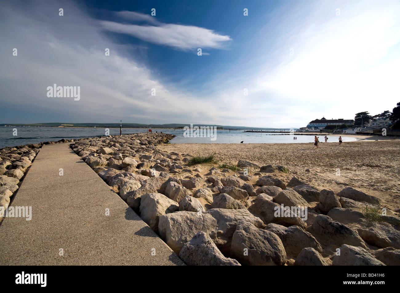 Rock groyne on Sandbanks beach with the Studland coastline in the ...