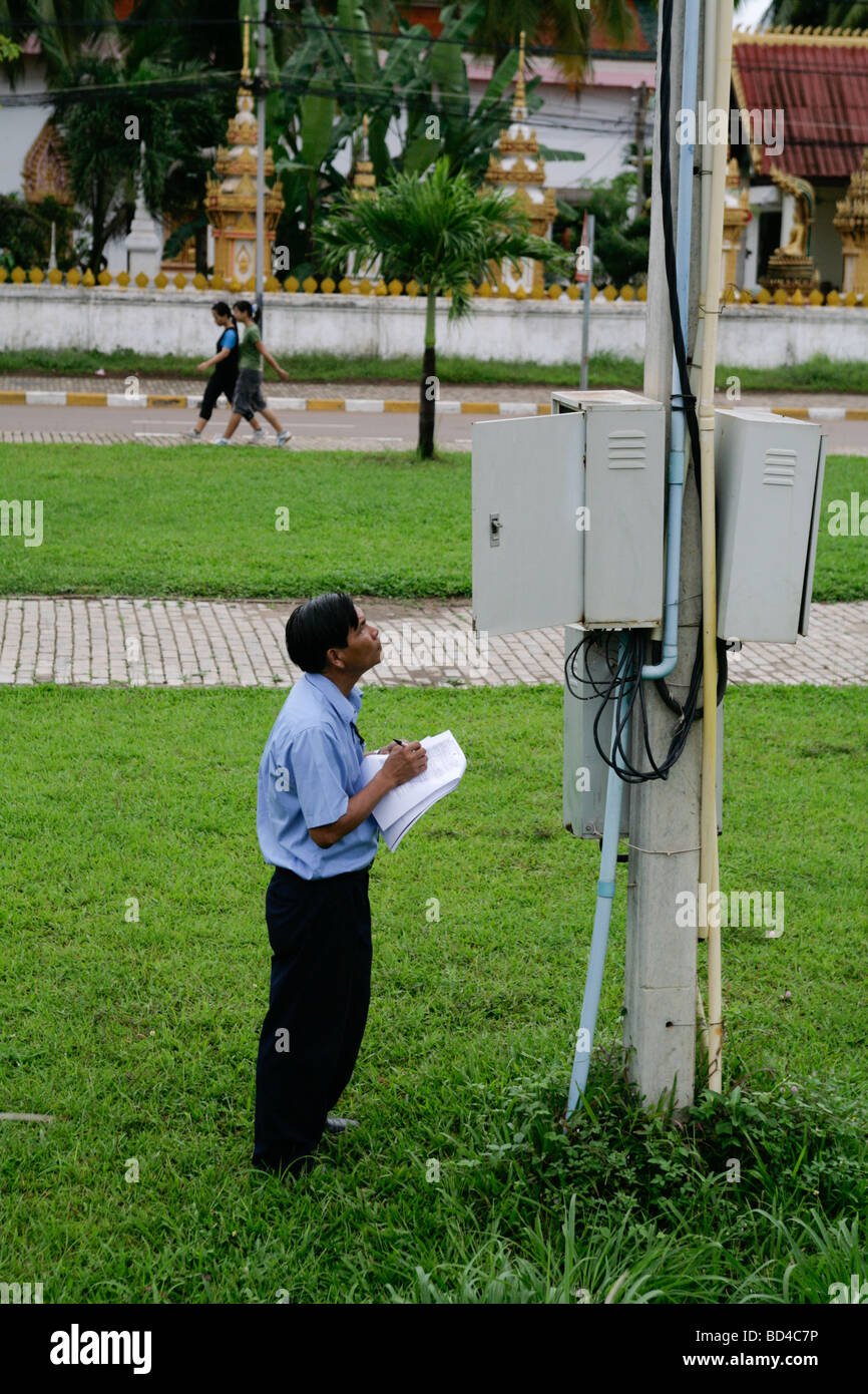 Vientiane Laos Indochina An electrician takes a meter reading from a ...