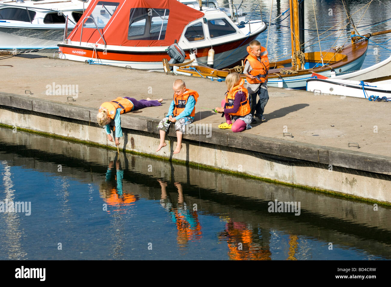 Summer scene from a harbor, kids and adults fishing crabs Stock Photo ...