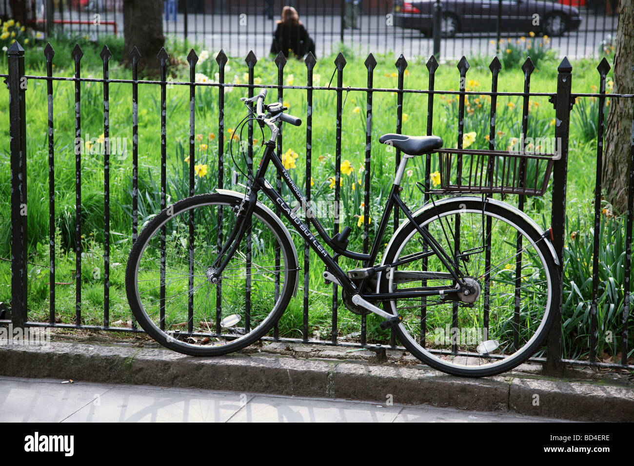 Bicycle chained up to a fence Stock Photo - Alamy
