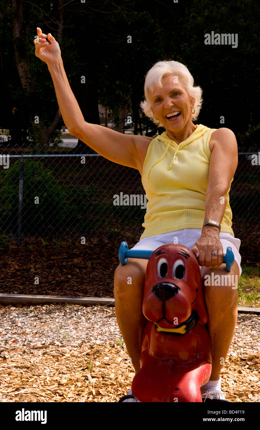 Senior retired woman playing at childs playground and having fun Stock ...