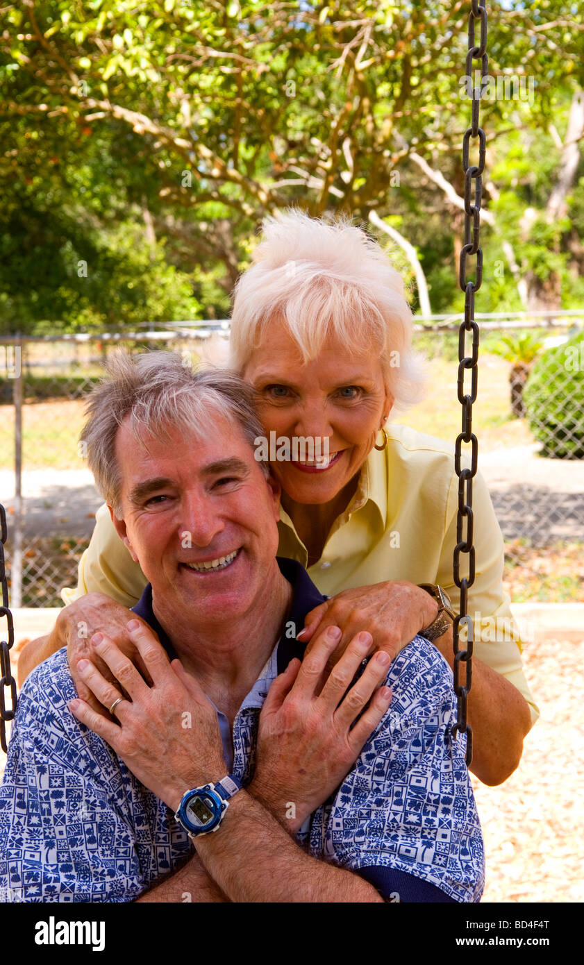 Retired senior couple having fun together at playground on swing Stock ...